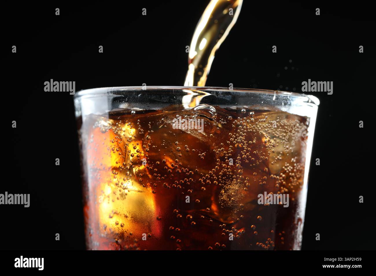 Pouring refreshing cola into glass on black background, closeup Stock ...