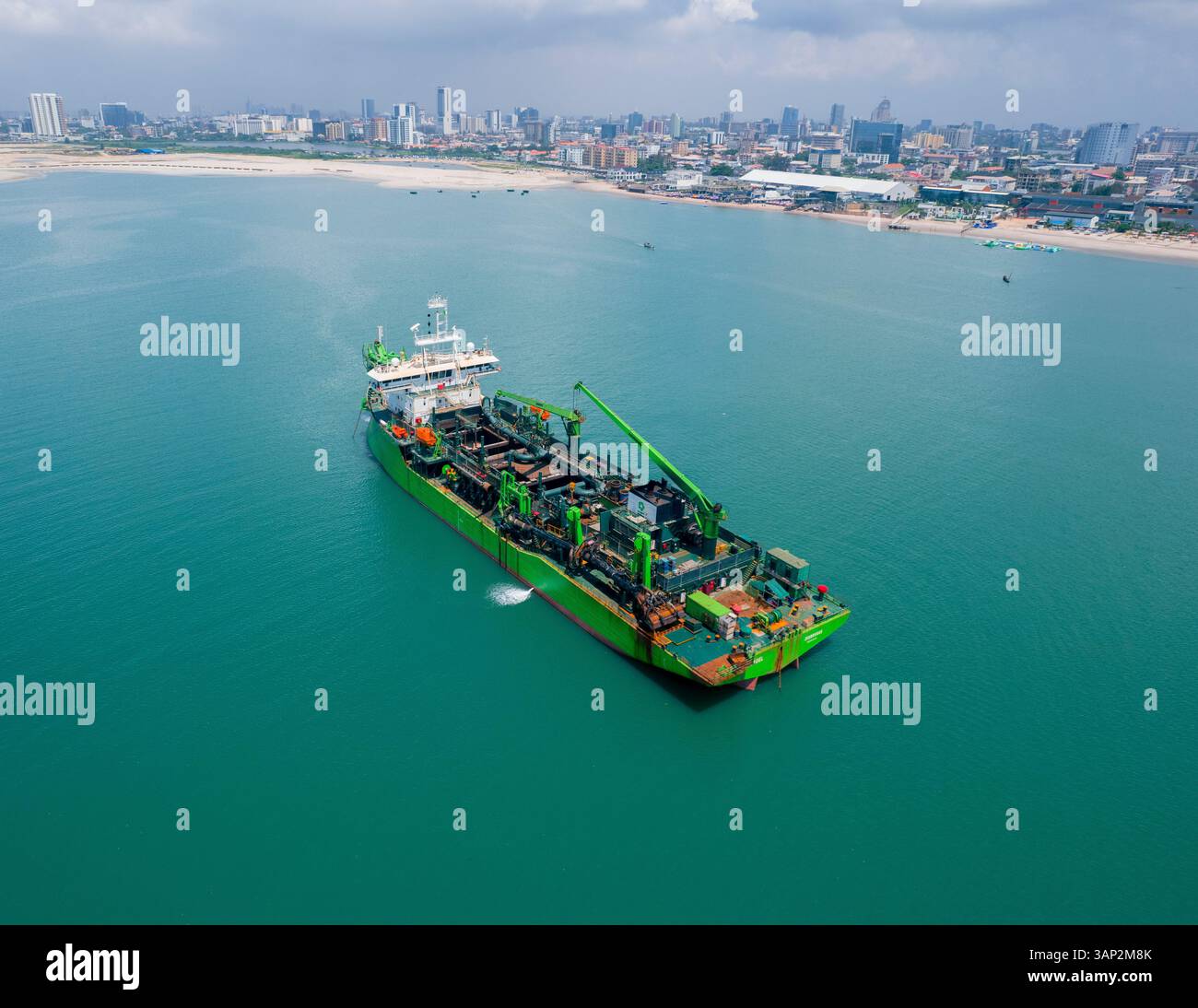 Aerial view of a sand dredger and ships in a bustling harbor with a ...