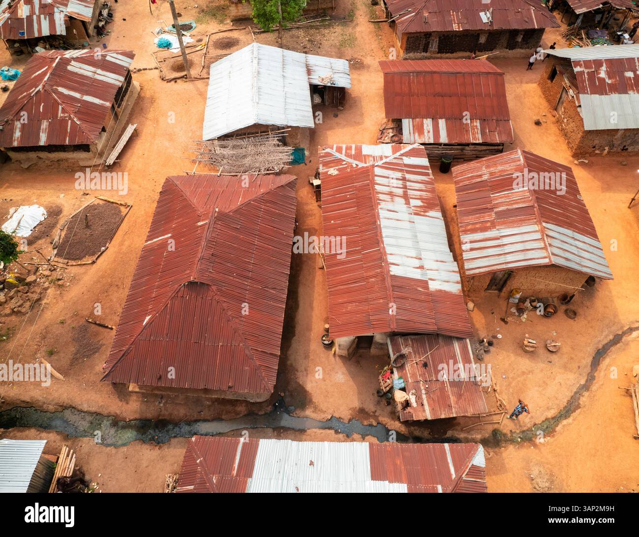 Aerial view of rustic village with red rooftops and dirt roads, Irewole ...