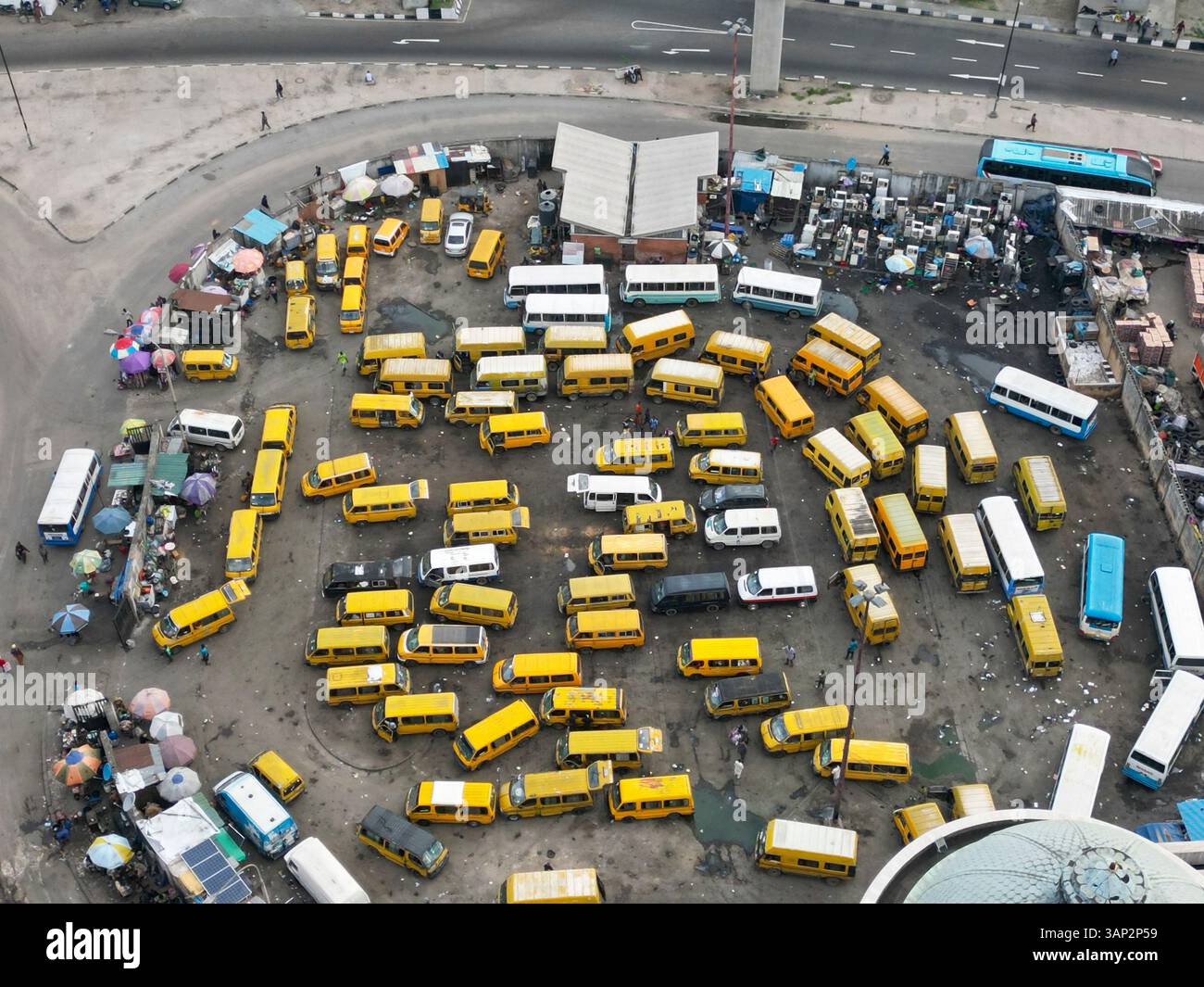 Aerial view of bustling city life with yellow buses and crowded bus ...