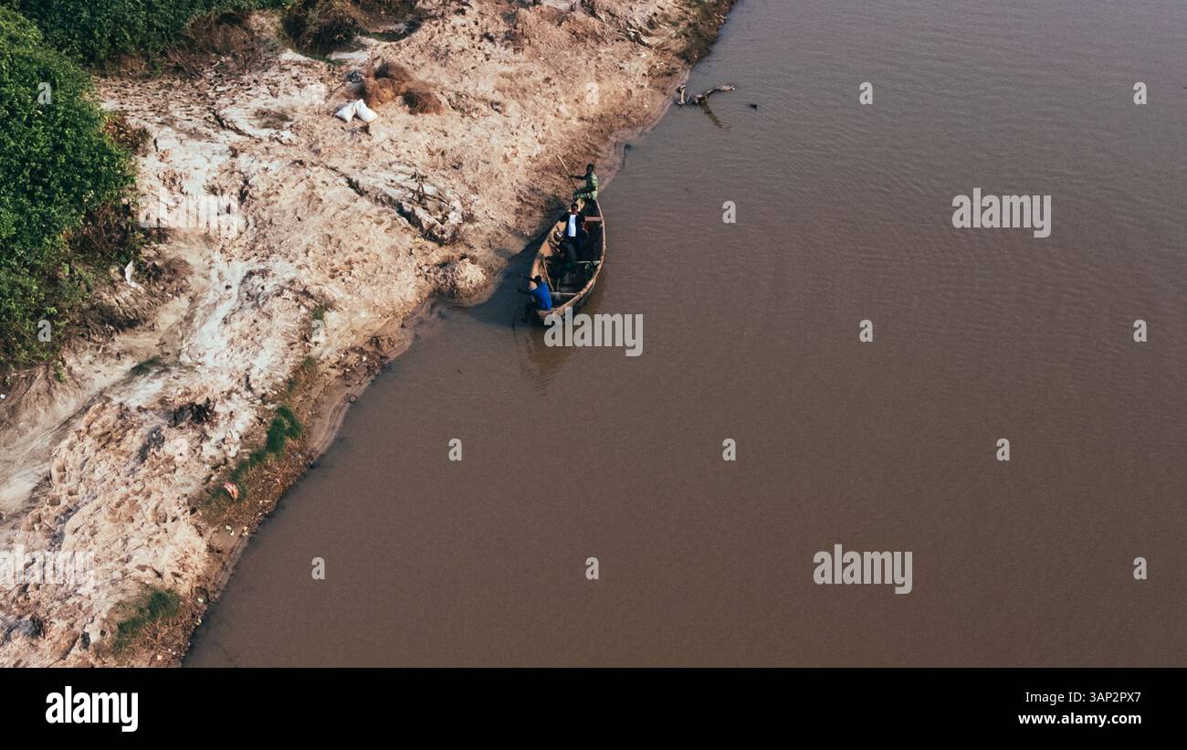 Aerial view of tranquil Ogun River with boats along the serene shore ...