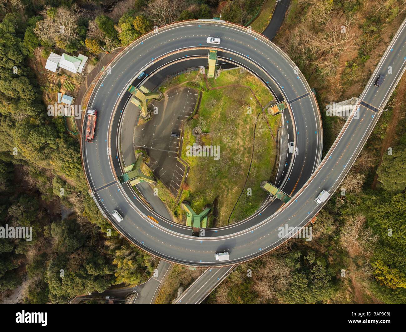 Aerial view of circular freeway ramp surrounded by lush greenery and ...