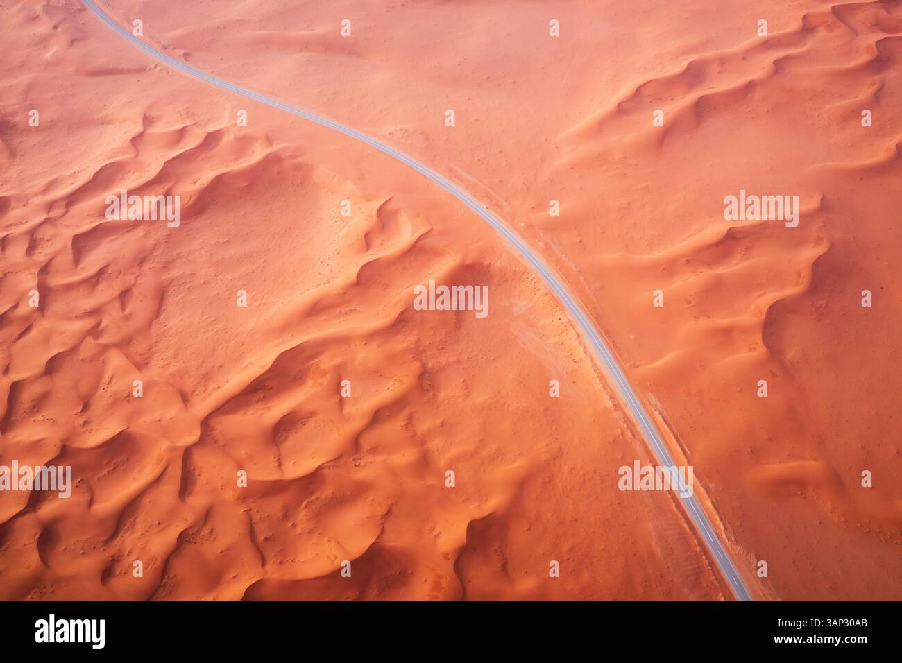 Aerial view of a road through beautiful sand dunes in an arid landscape ...