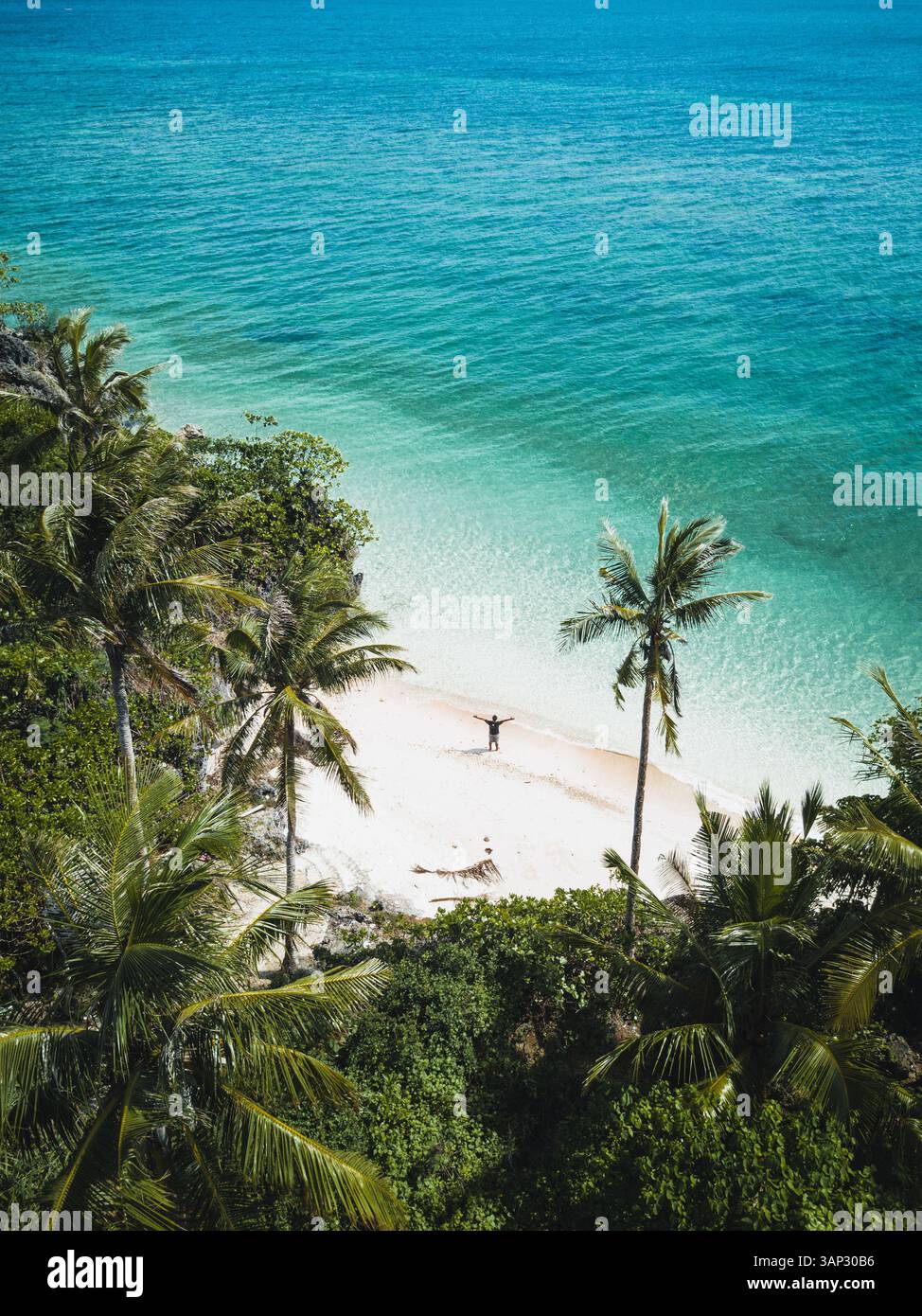 Aerial view of a man on the shore of the beach in Candabong, Anda ...
