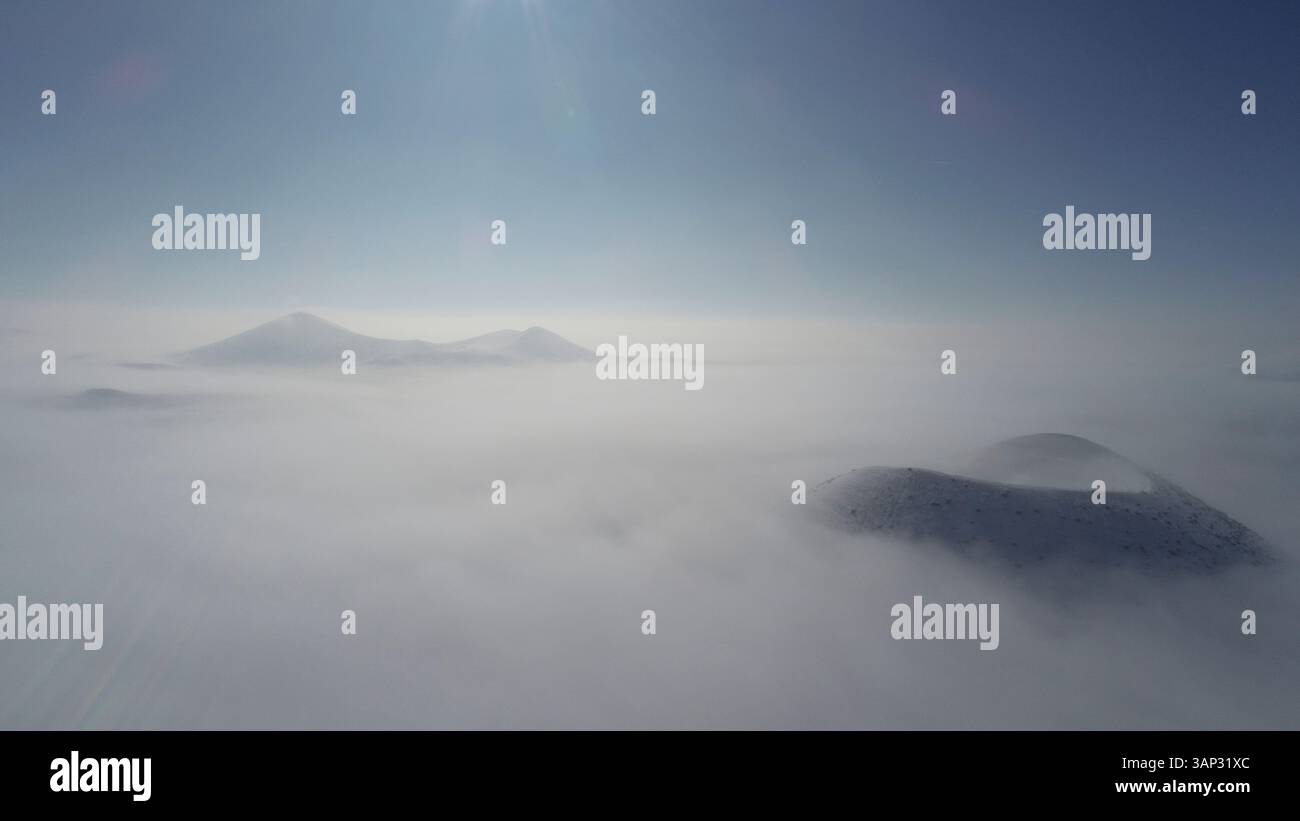 Aerial view of serene mountain landscape with fog and clouds at sunrise ...