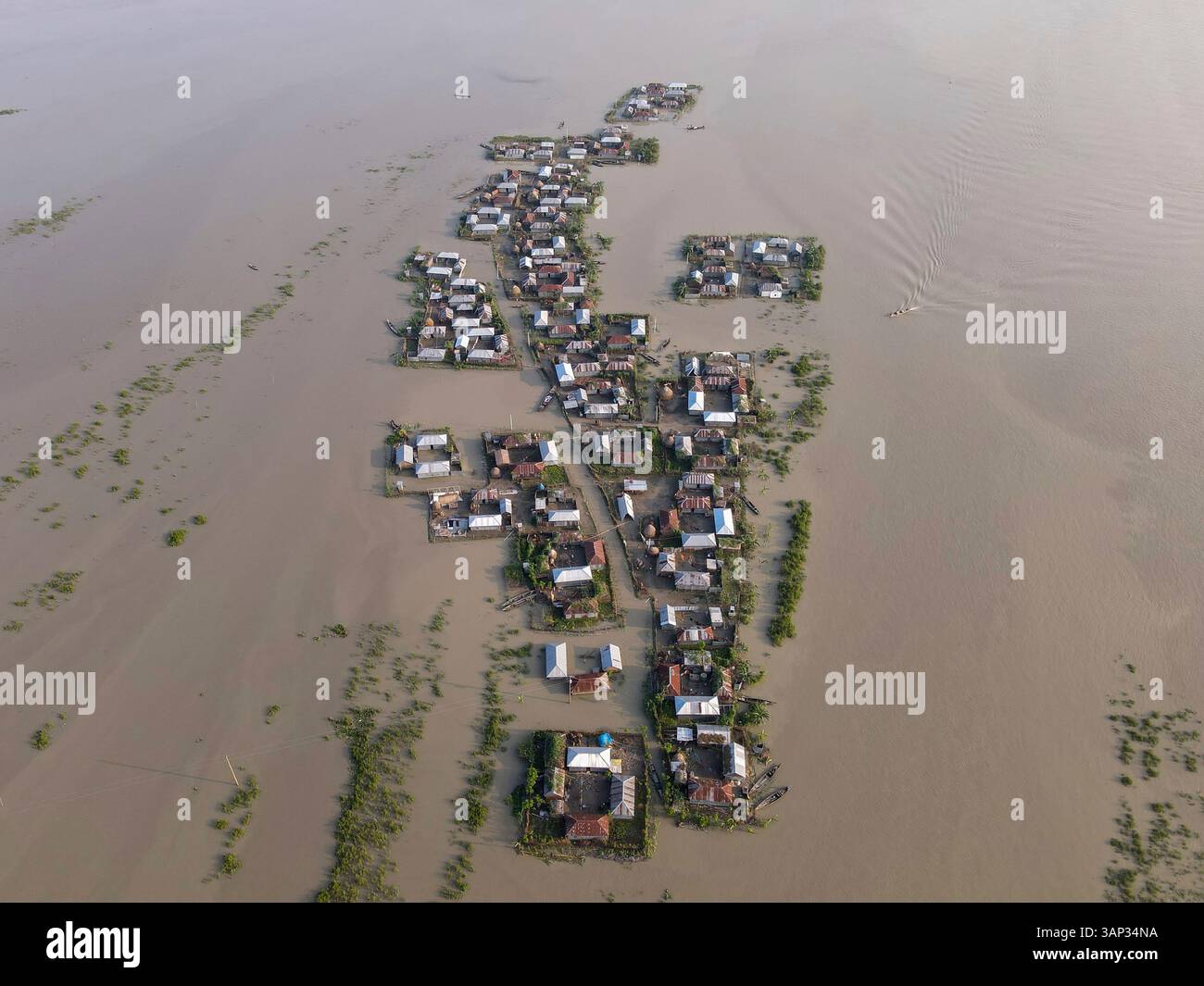 Aerial view of flood water surrounding homes and boats in a damaged village, Jatrapur, Kurigram ...