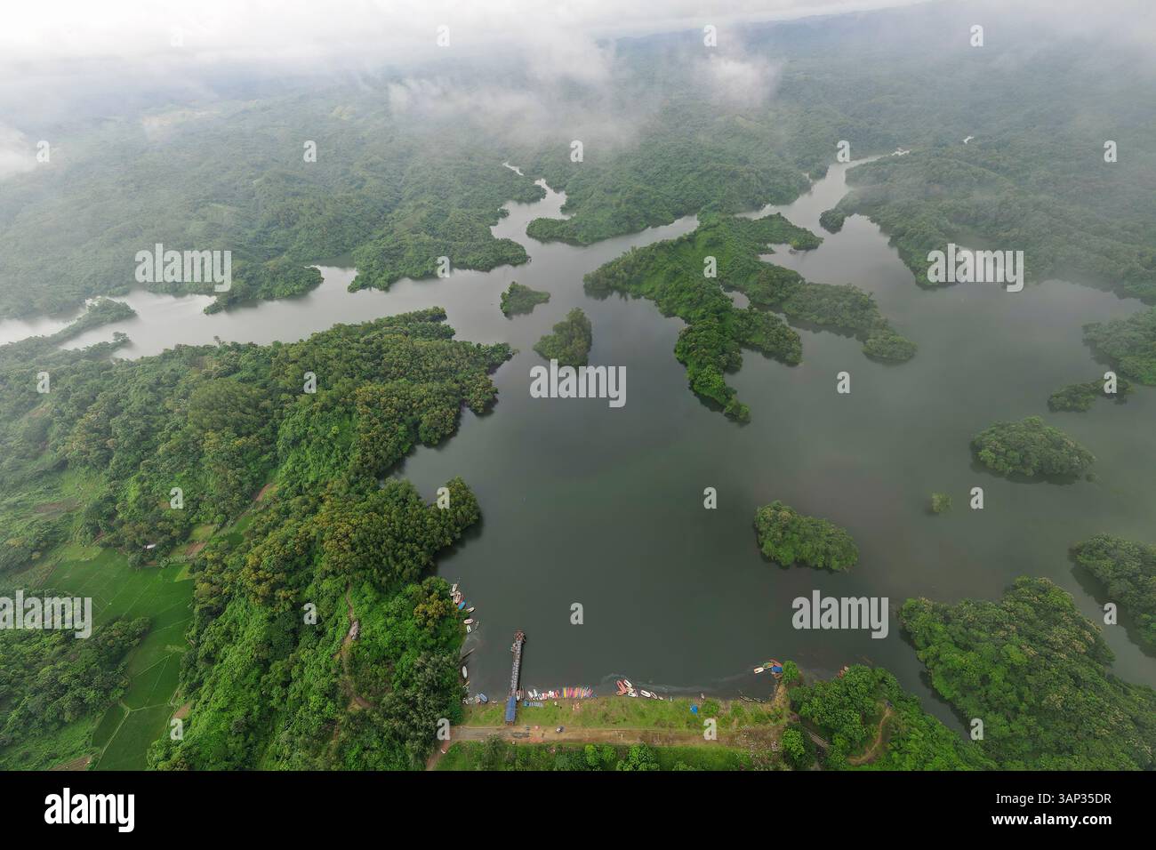 Aerial view of serene Mohamaya lake surrounded by lush greenery and ...