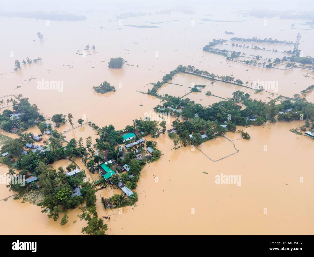 Aerial view of flooded village with submerged houses and greenery, Jhenaigati, Sherpur ...