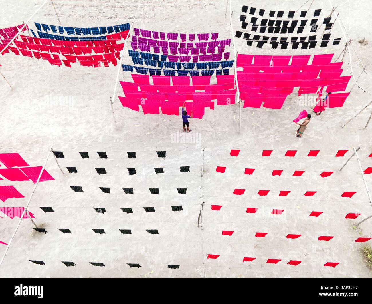 Aerial view of vibrant hand-dye fabrics drying in the sun at a factory ...
