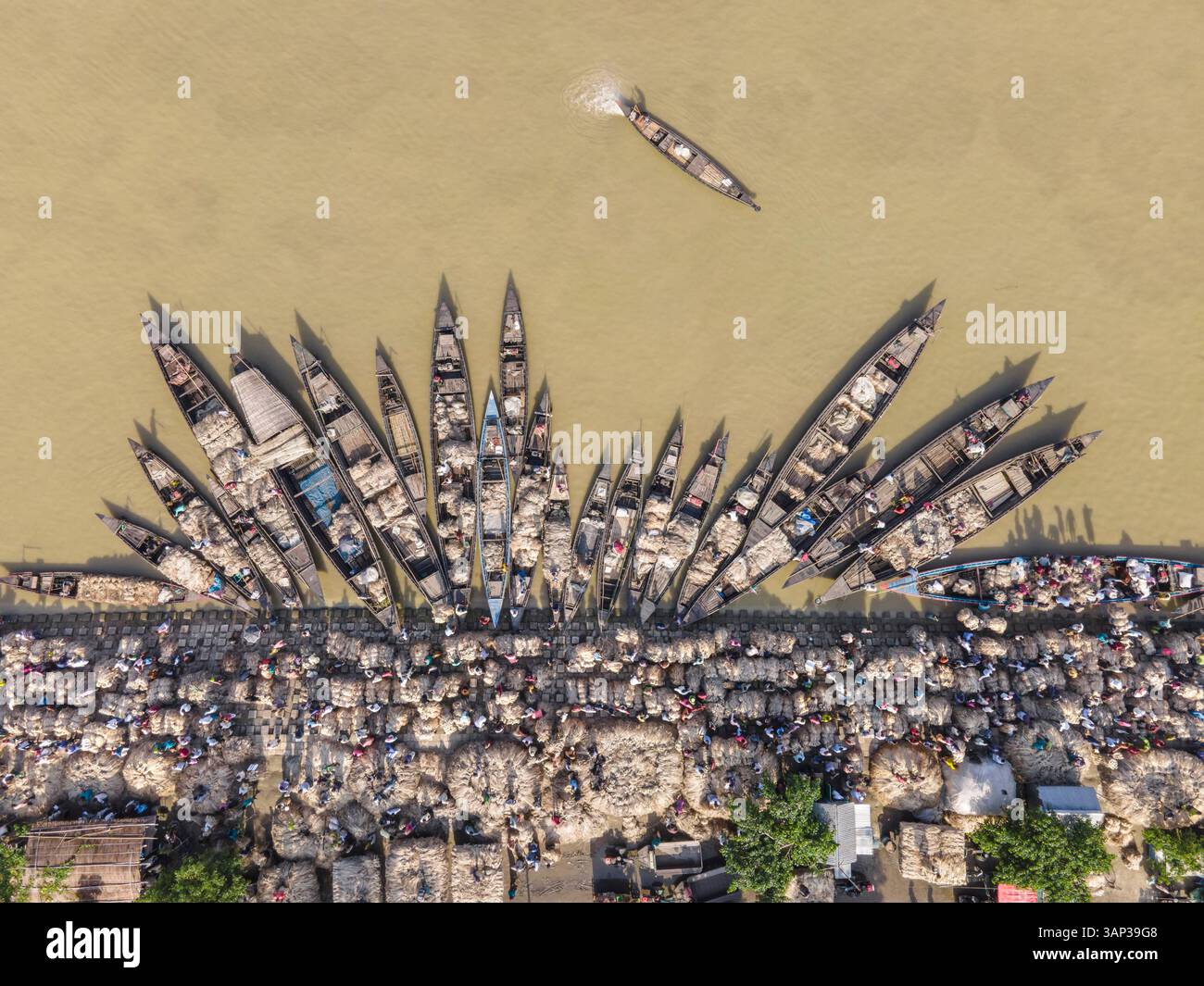 Aerial view of a busy jute market with colorful boats on the river ...
