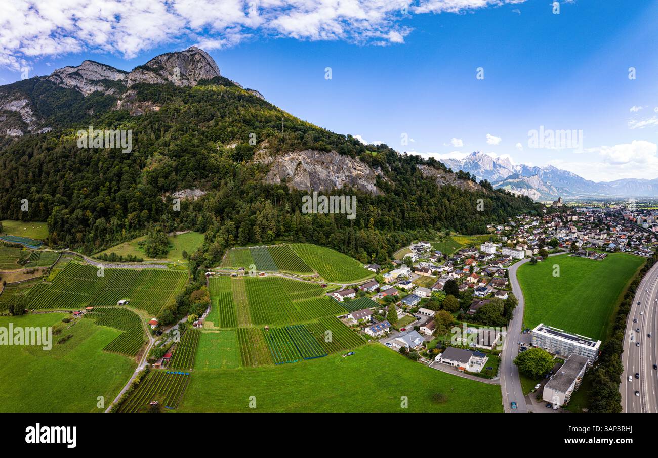 Aerial view of serene village and lush green fields in a valley ...