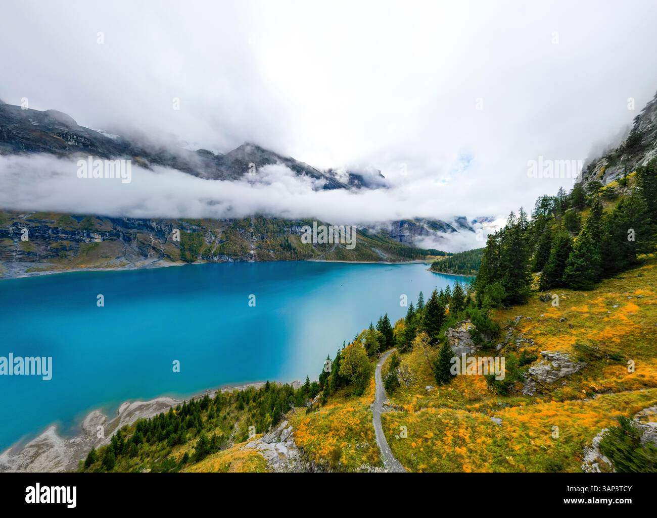 Aerial view of Lake Oeschinen surrounded by mountains and forests ...