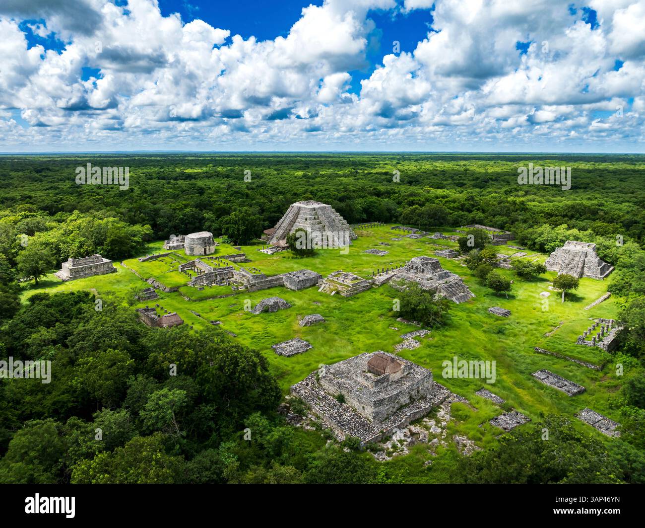 Aerial view of ancient mayapan ruins surrounded by lush greenery and a ...