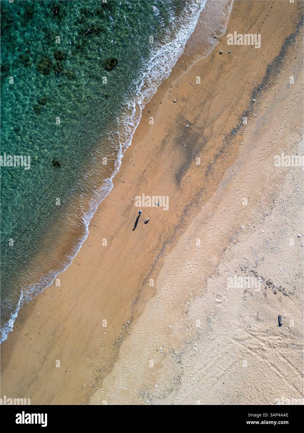 Aerial view of serene Adan Beach with clear blue water and sandy ...