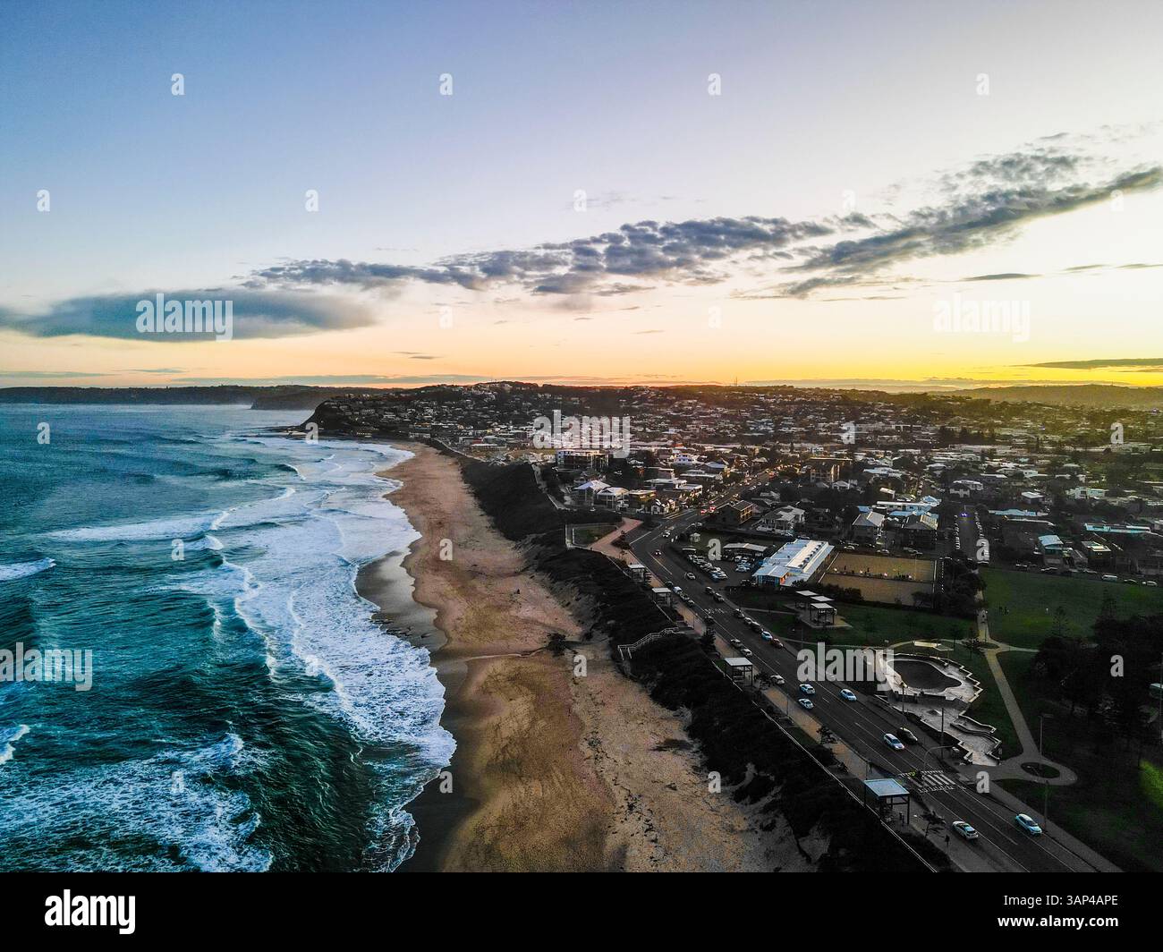 Aerial view of beautiful beach and ocean waves with cityscape and sandy ...