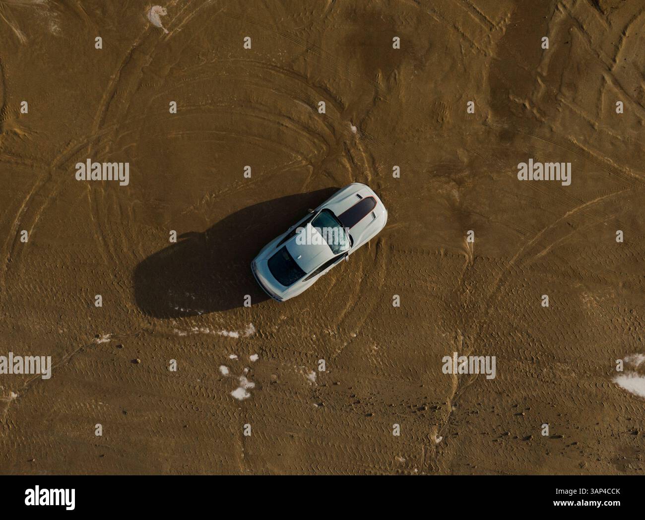 Aerial view of the Ford Mustang Mach 1 driving true a large puddle ...