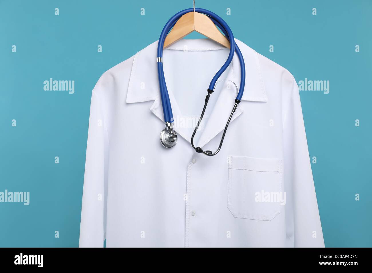 Doctor's coat with stethoscope on hanger against blue background Stock ...