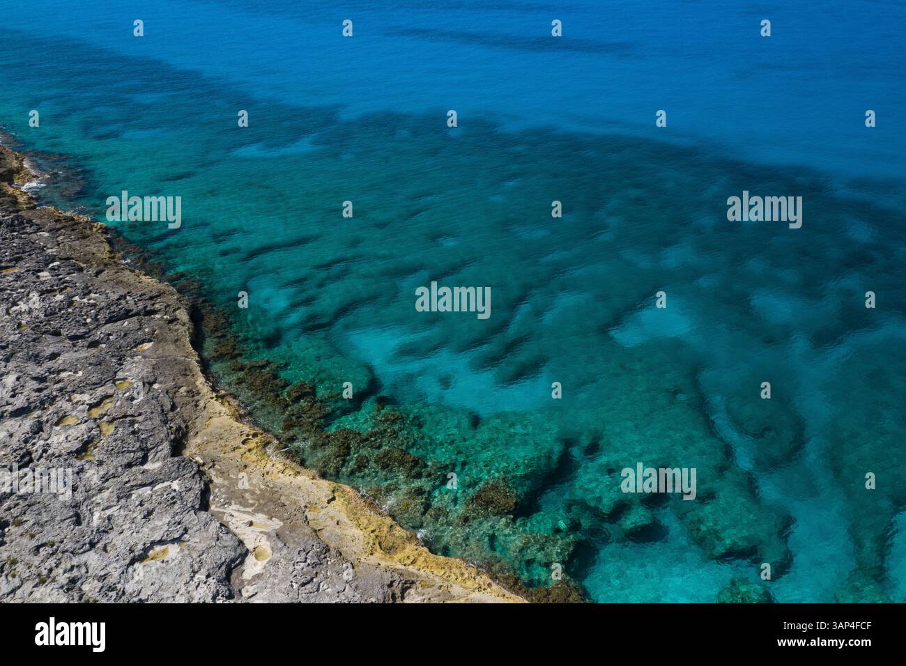Aerial View of rocky iron shore coastline with calm crystal clear water ...