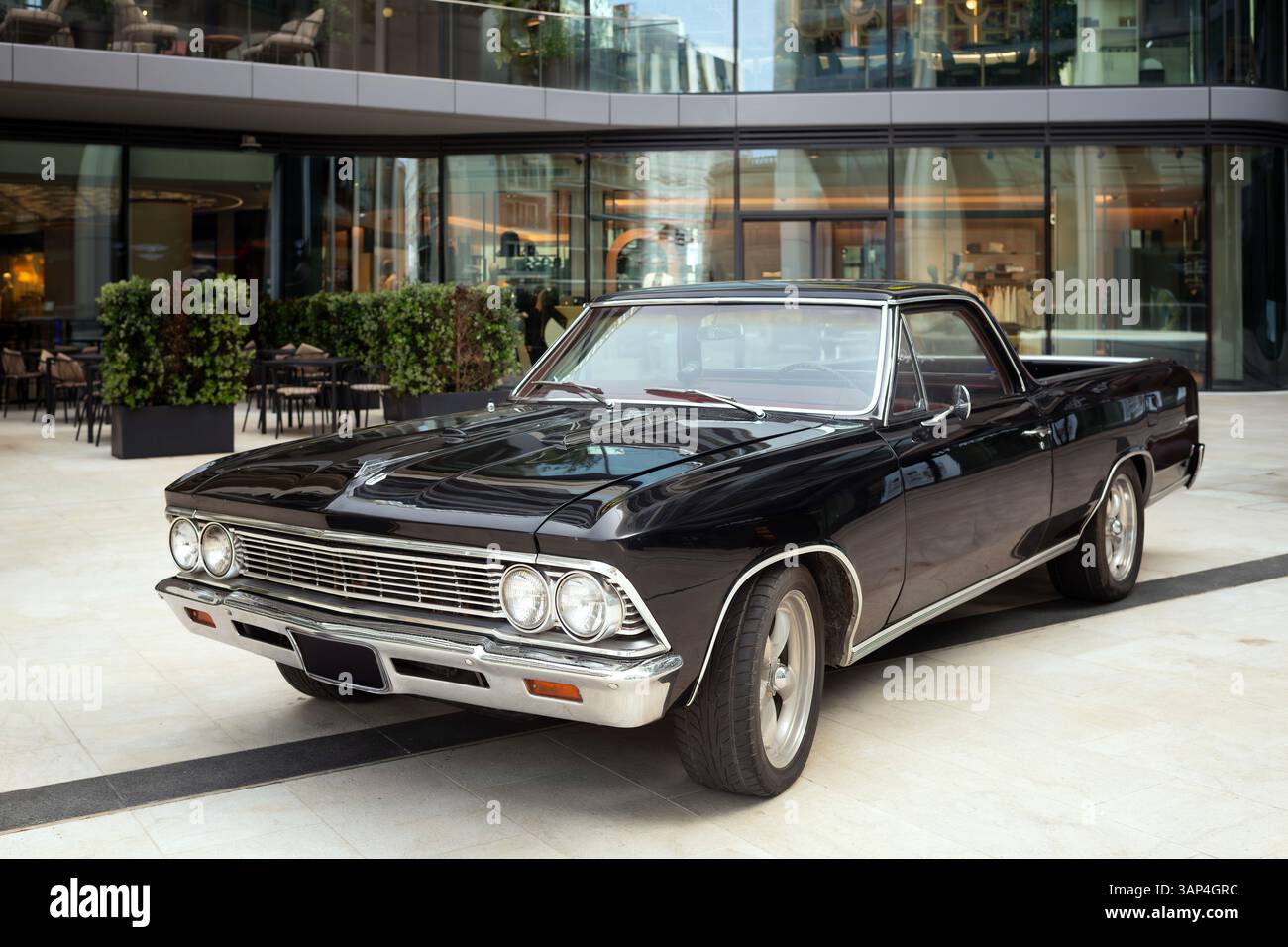 Vintage black car parked in a modern courtyard. Sharp focus on ...