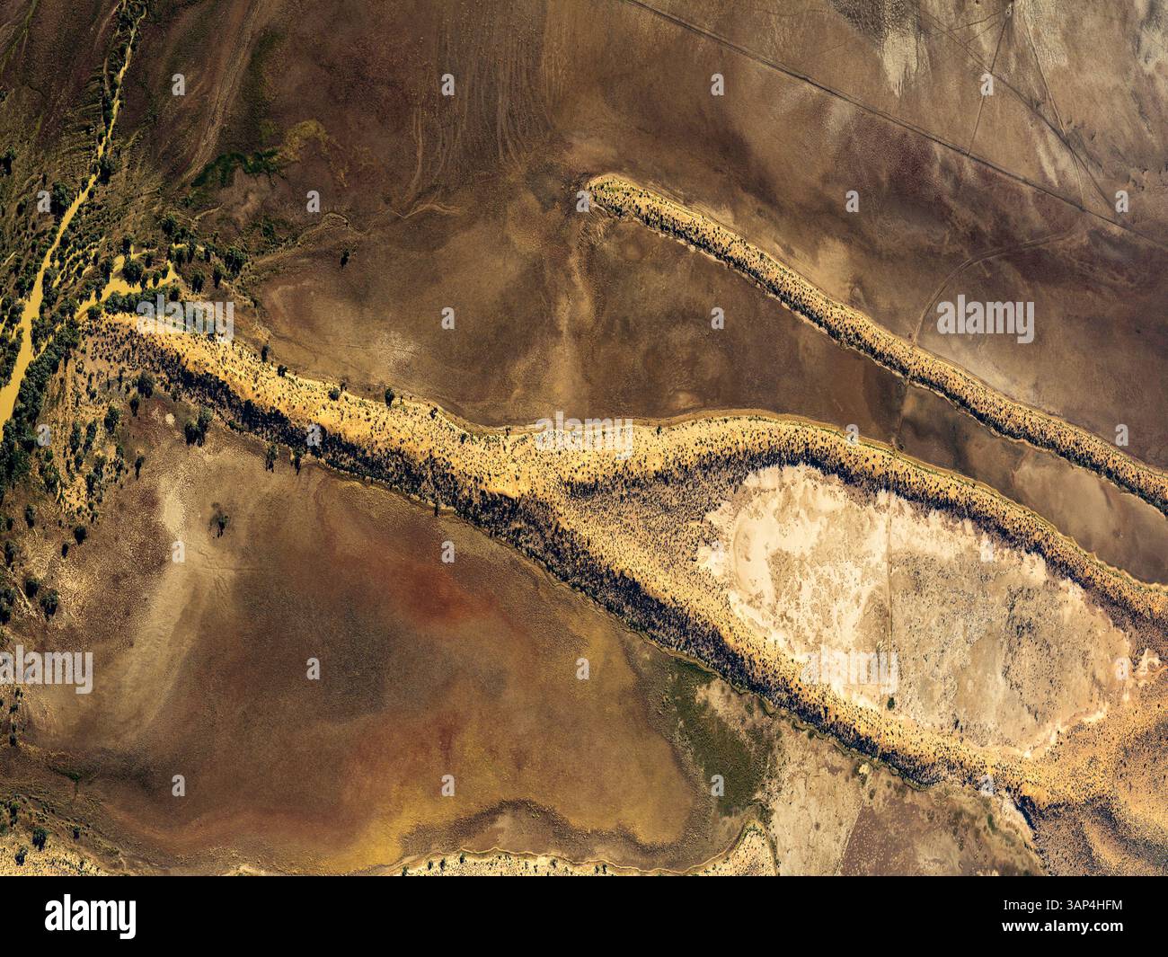Aerial view of dry riverbed and flood plain in arid outback terrain ...