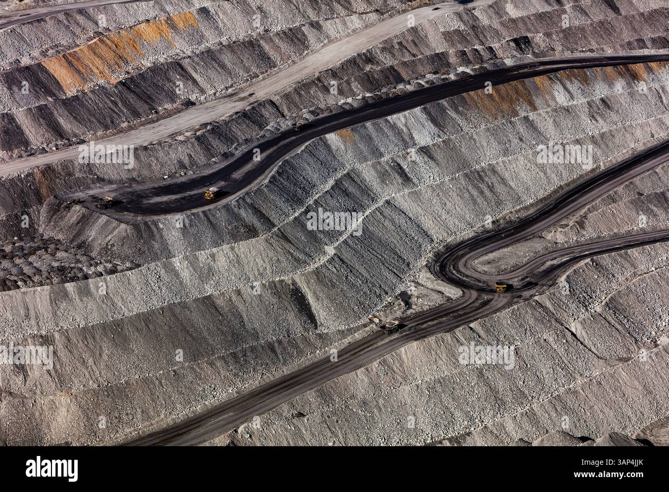Aerial view of open cut coal mining with roads, vehicles, and machinery ...