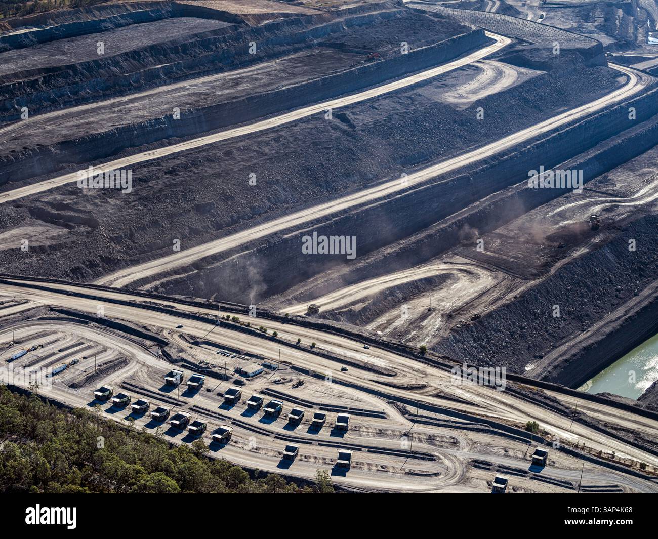 Aerial view of open cut coal mining with trucks and machinery in ...