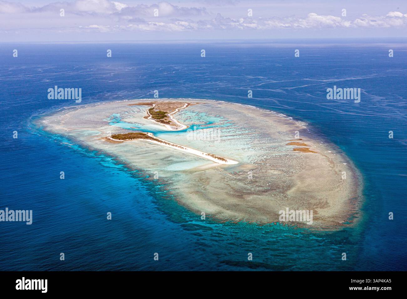 Aerial view of tranquil reef and uninhabited island in clear water ...