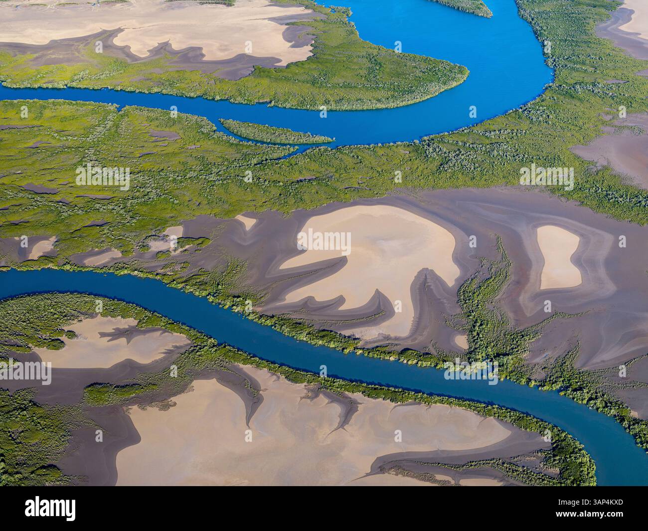 Aerial view of meandering river and tidal flats with winding sand dunes ...