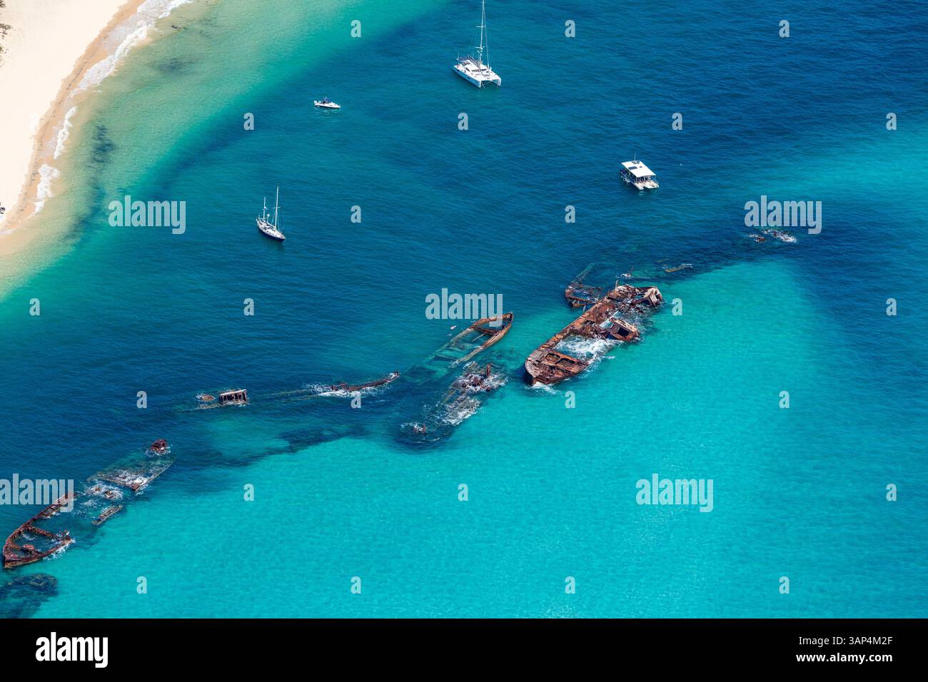 Aerial view of Tangalooma ship wrecks, boats, and clear turquoise water ...