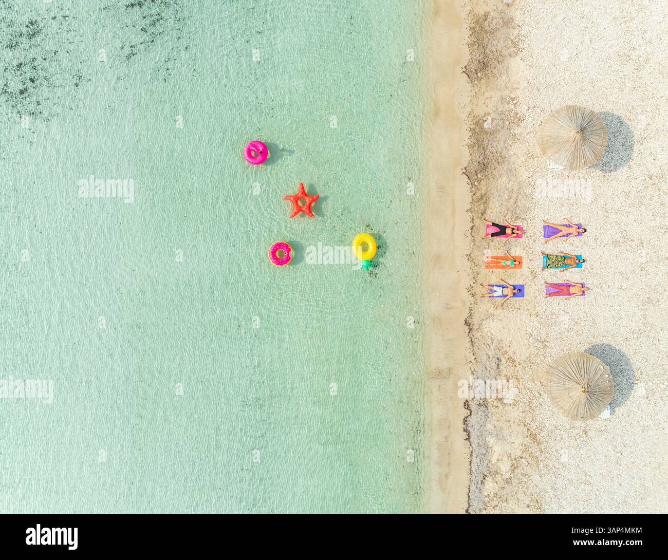Aerial view of people lying in yoga pose on on the with inflatables ...