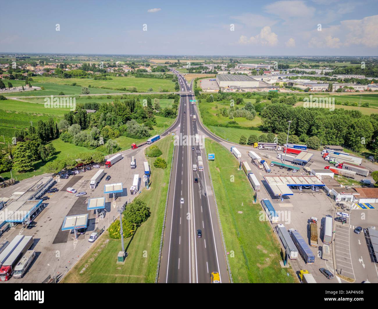 Aerial view of a busy highway with trucks and a gas station surrounded ...