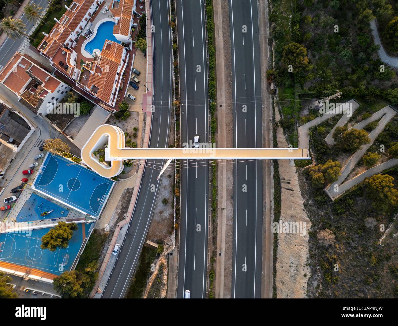 Aerial view of residential area with foot bridge, highway, and ...