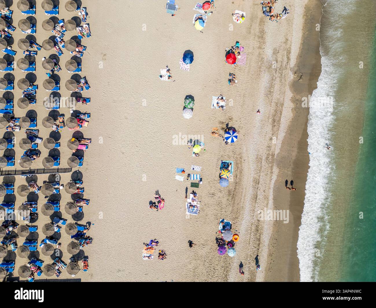Aerial view of crowded beach scene with sunloungers, umbrellas, and ...