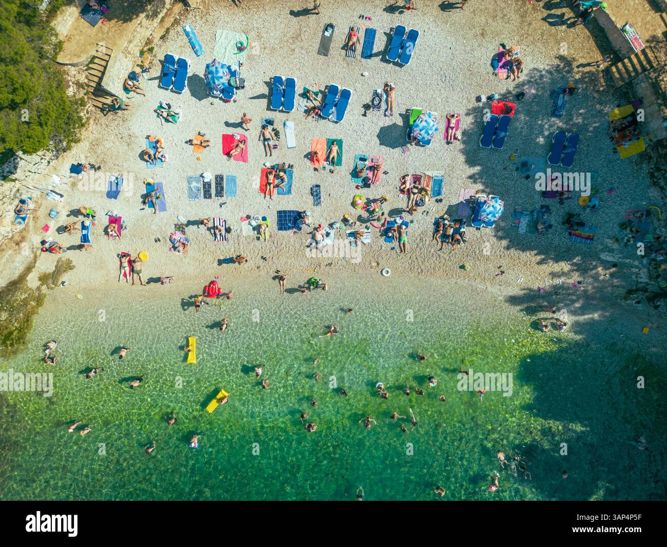 Aerial view of people relaxing at Gortanova beach, a narrow inlet with ...