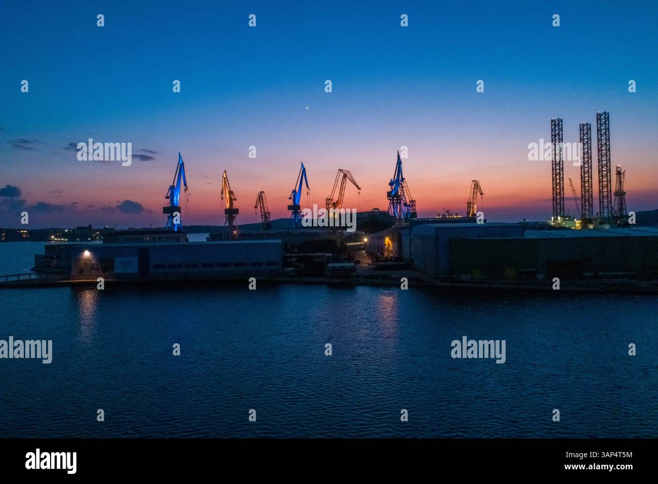 Aerial view of industrial cranes coloured with Ukrainian colours flags ...