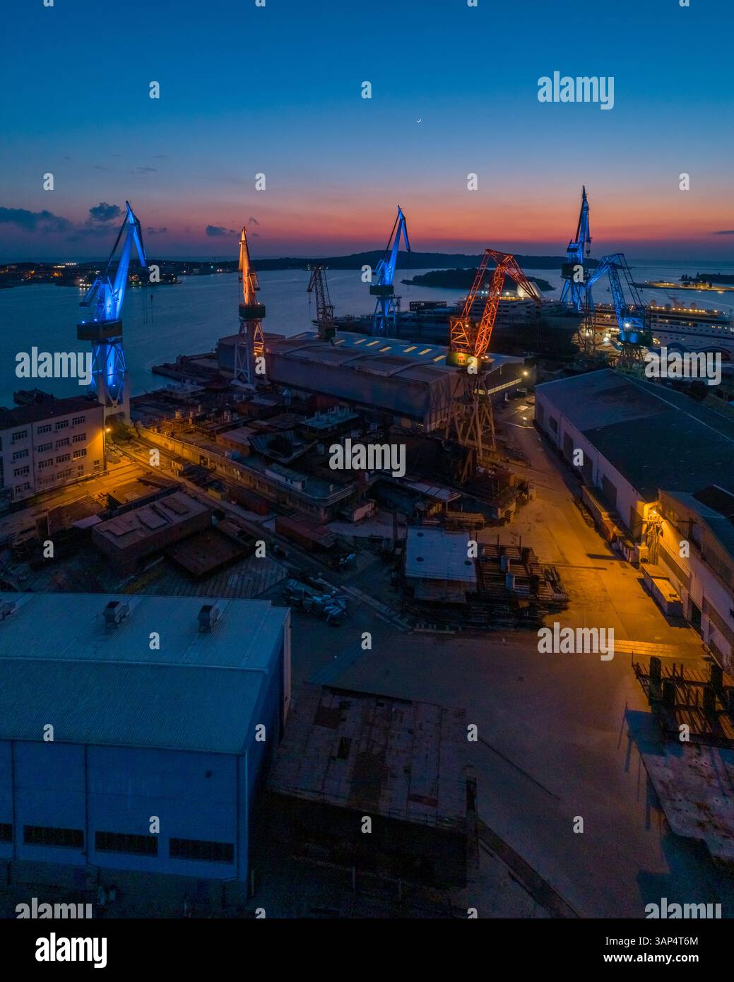 Aerial view of industrial cranes coloured with Ukrainian colours flags ...