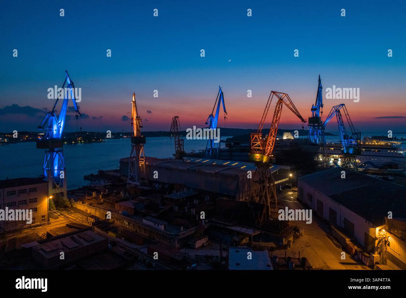 Aerial view of industrial cranes coloured with Ukrainian colours flags ...