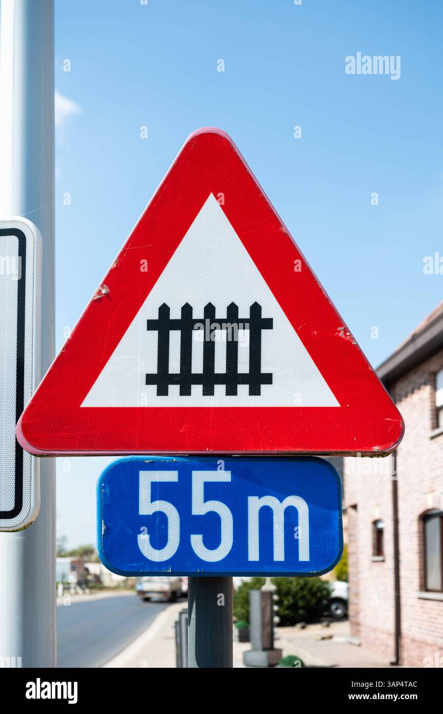 Road warning sign of a railway crossingat 55 m in the village of Erpe Mere, East Flemish Region ...