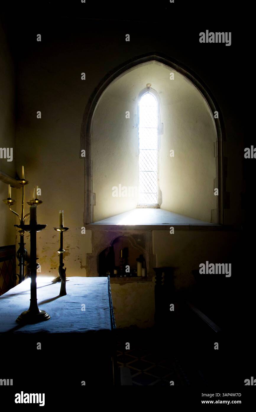 light streaming through an arch shaped church window the light is ...