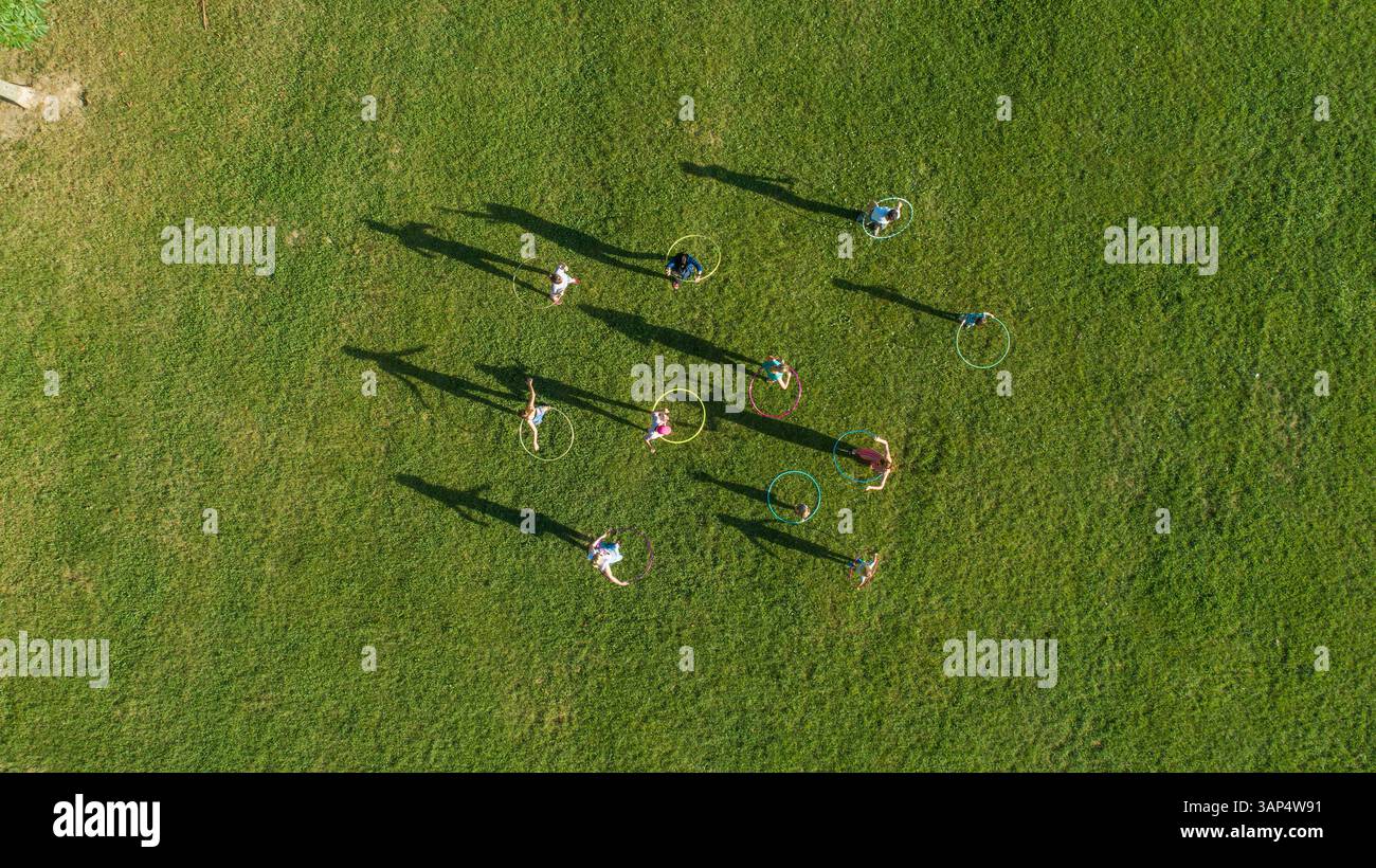 Aerial view of persons doing Hula Hoop in group at Tudmana Park, a ...