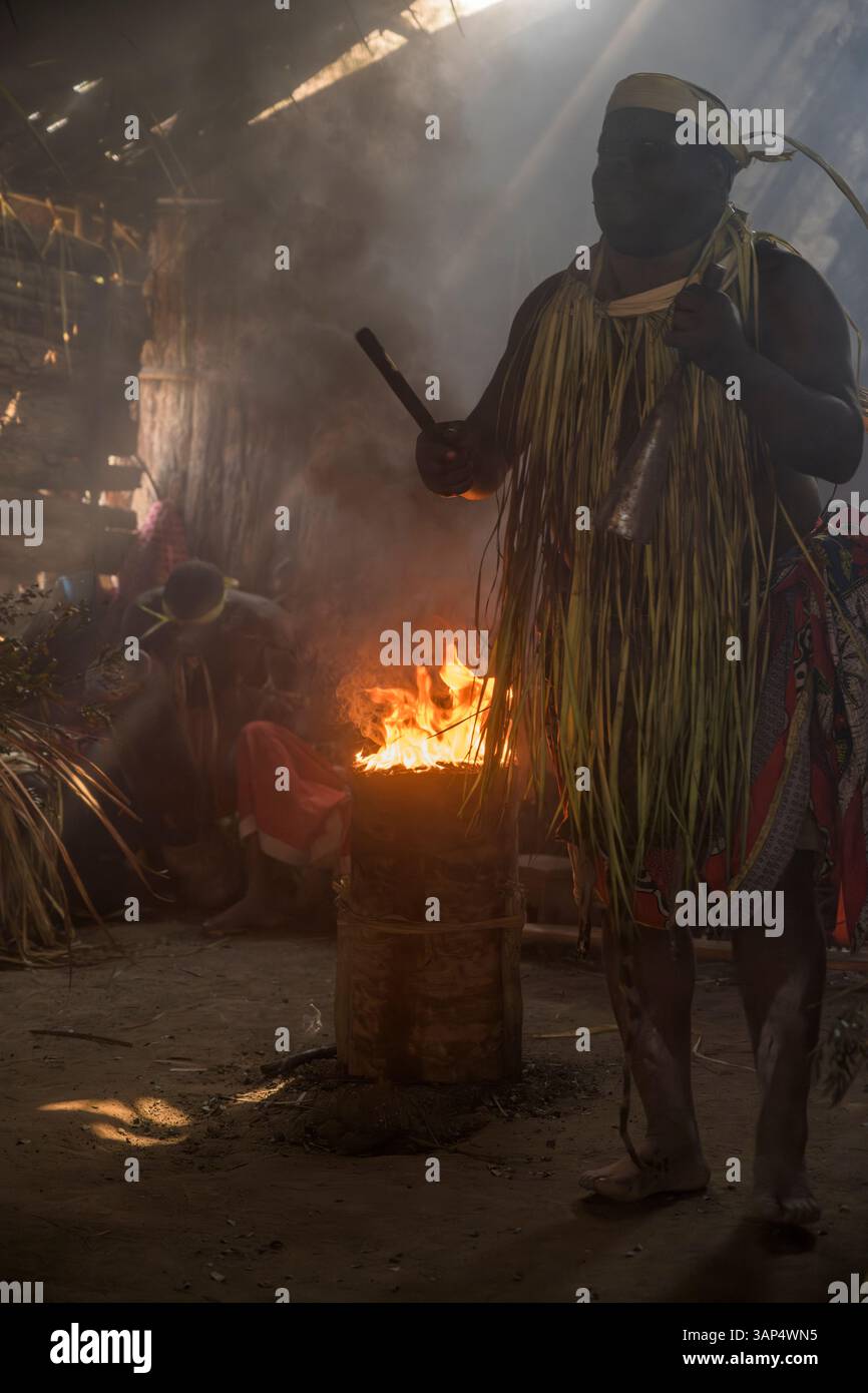Portrait of a man by the sacred fire, dressed in a ritual costume made ...