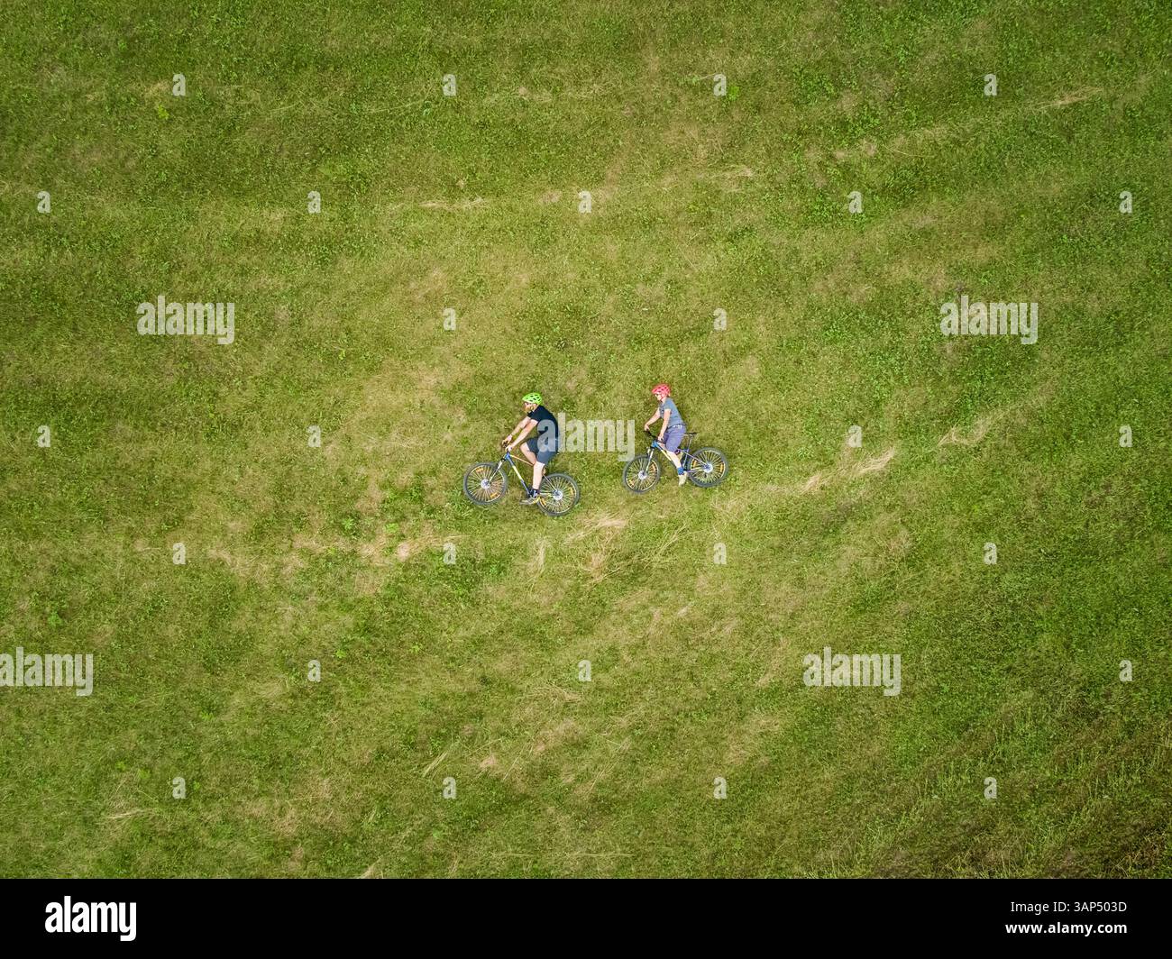 Aerial view of cyclists lying down on the grass with their bicycles in ...