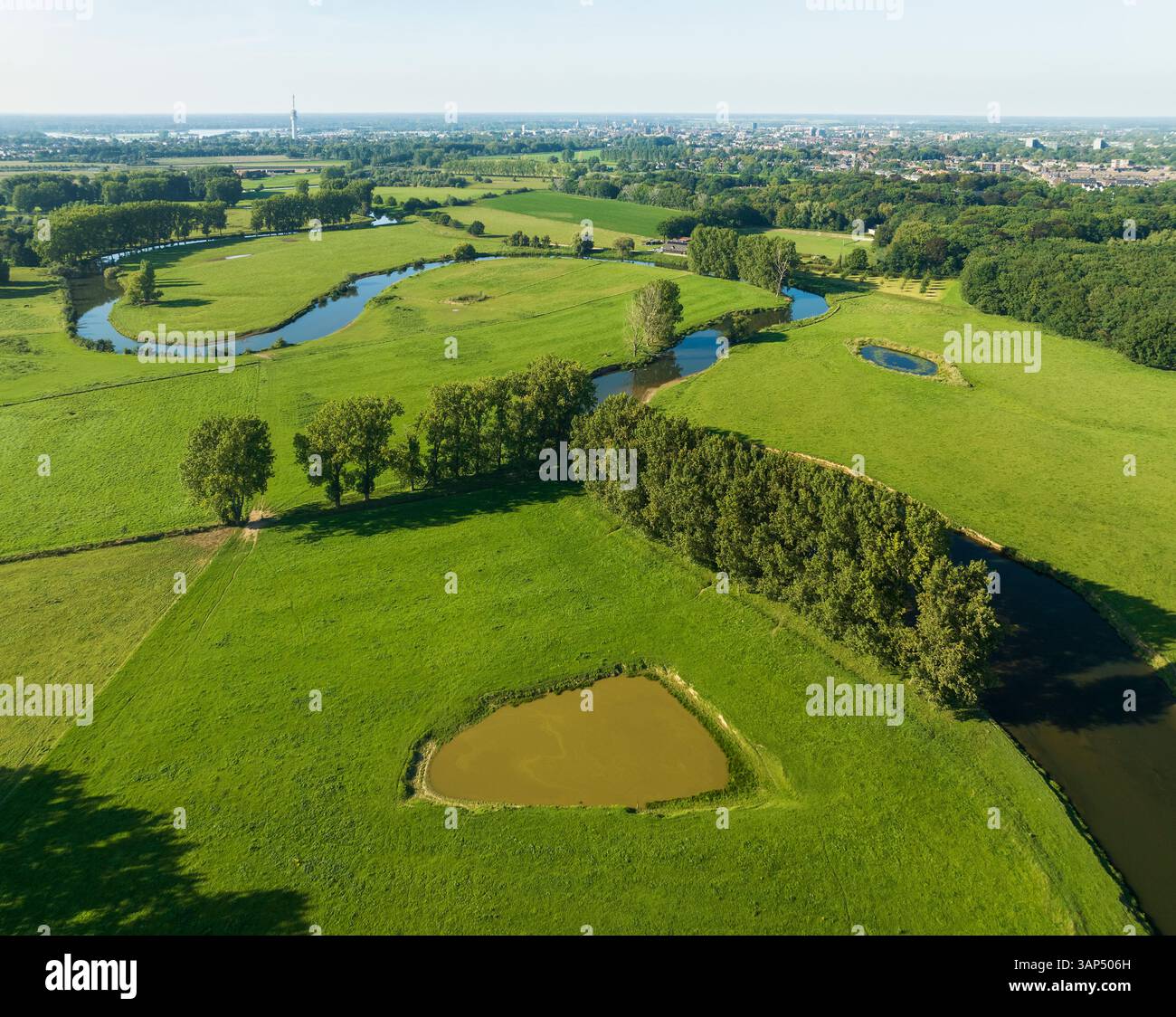 Aerial view of meandering river Roer with meadows and ponds in front of ...