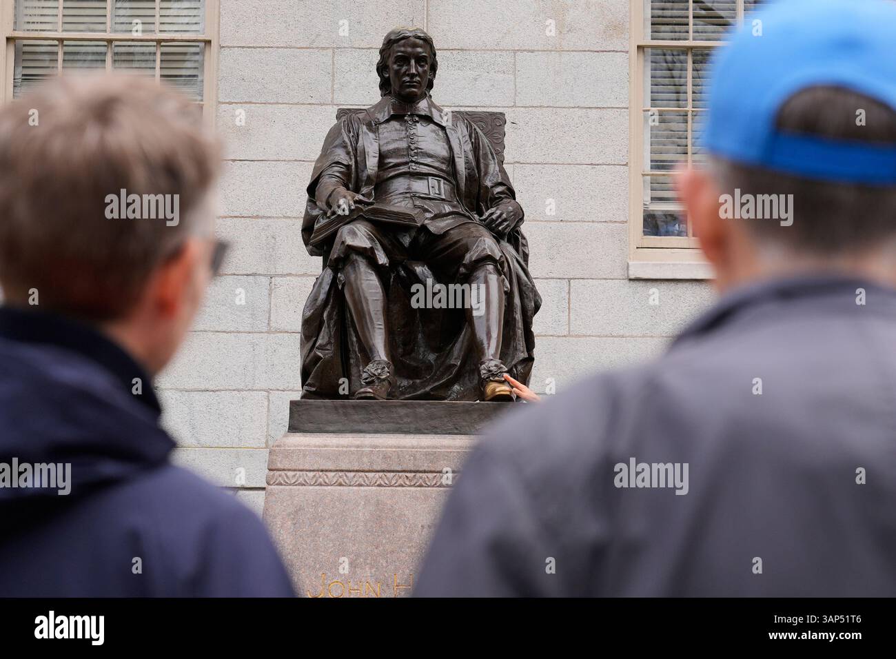 Visitors admire the statue of John Harvard in Harvard Yard at Harvard ...