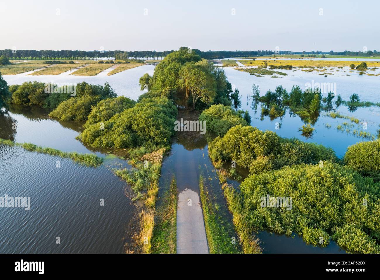 Aerial view of flooded floodplains of river Maas with submerged road ...