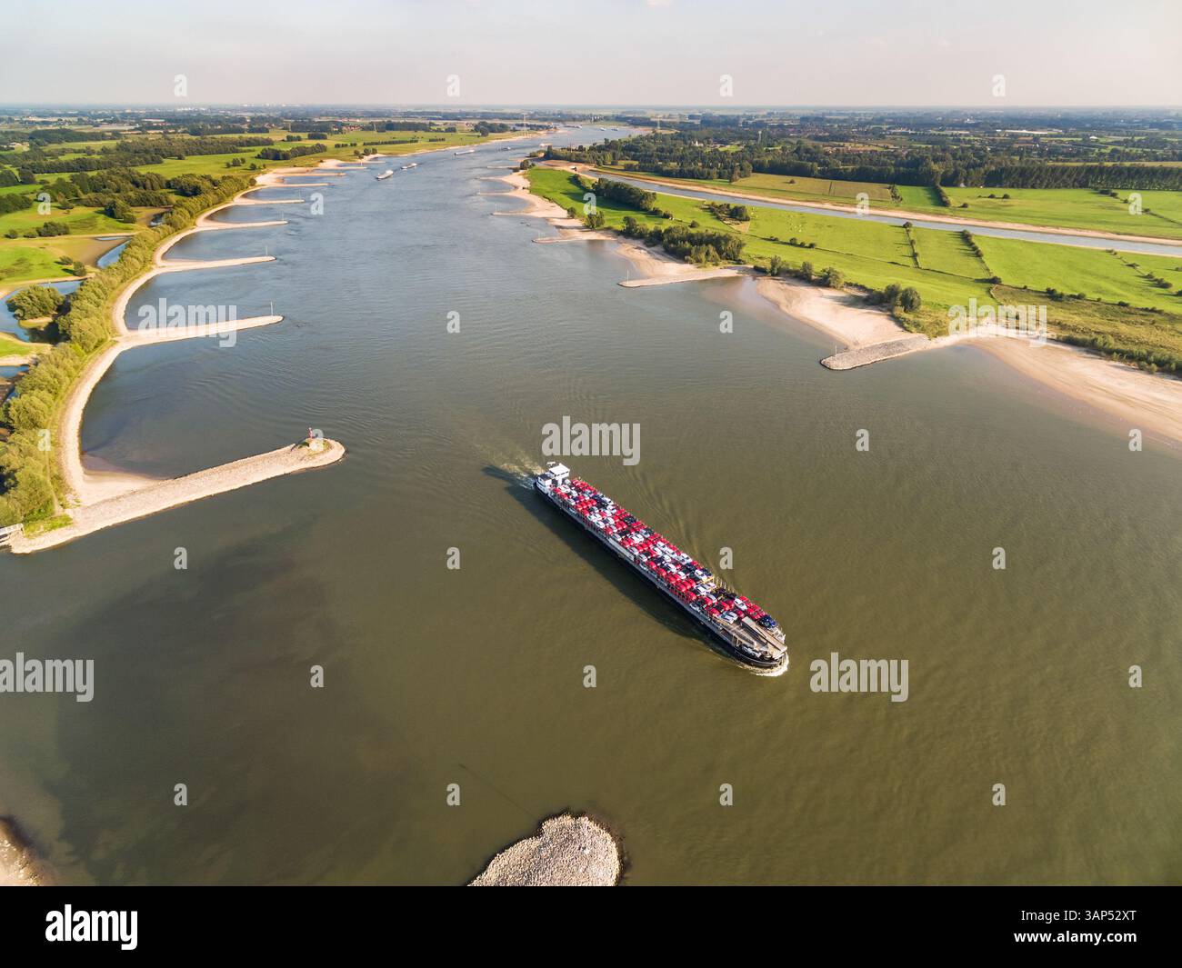 Aerial view of river Waal with cargo ship packed with cars, Opijnen ...