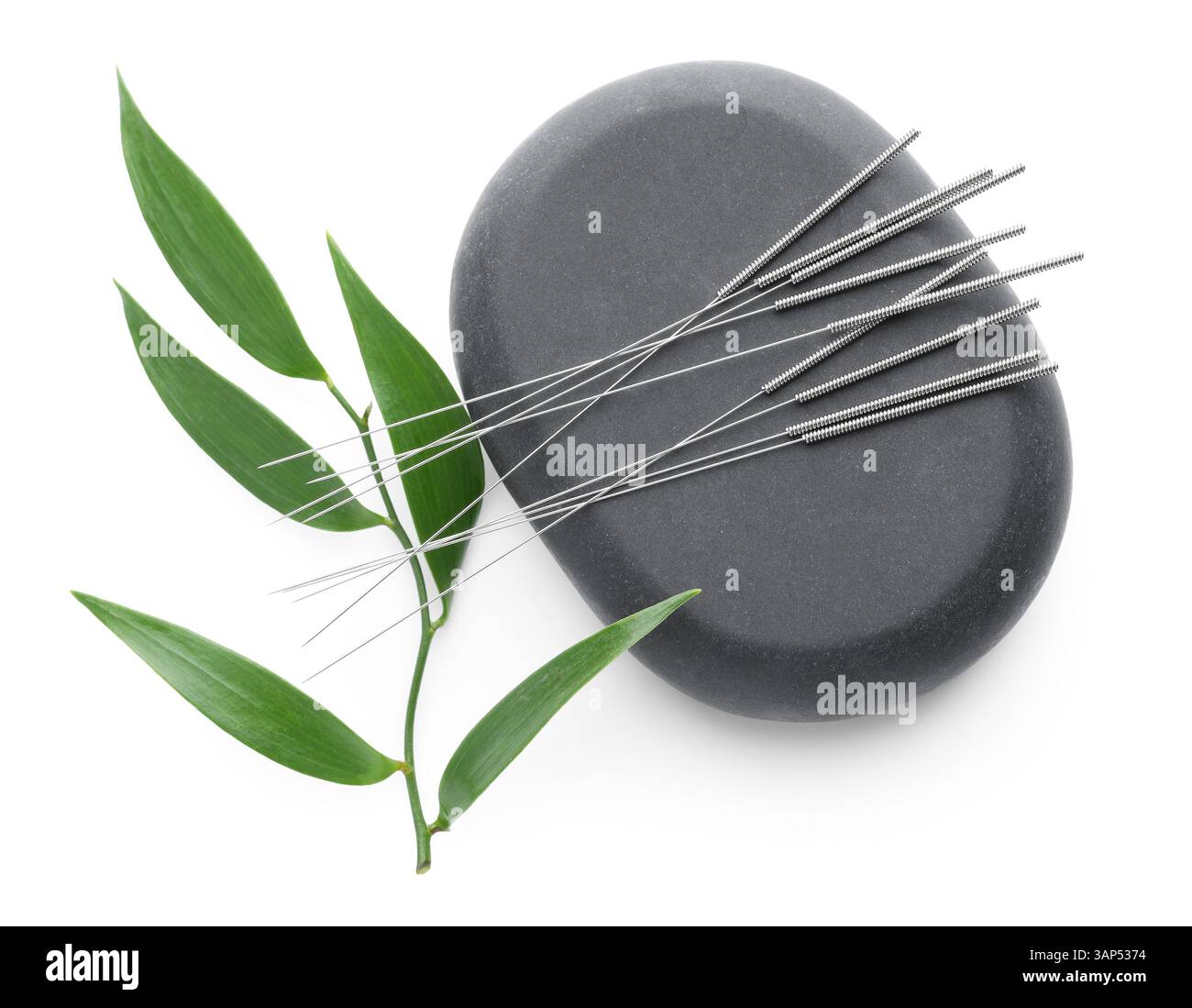 Acupuncture needles, spa stone and leaves isolated on white, top view ...