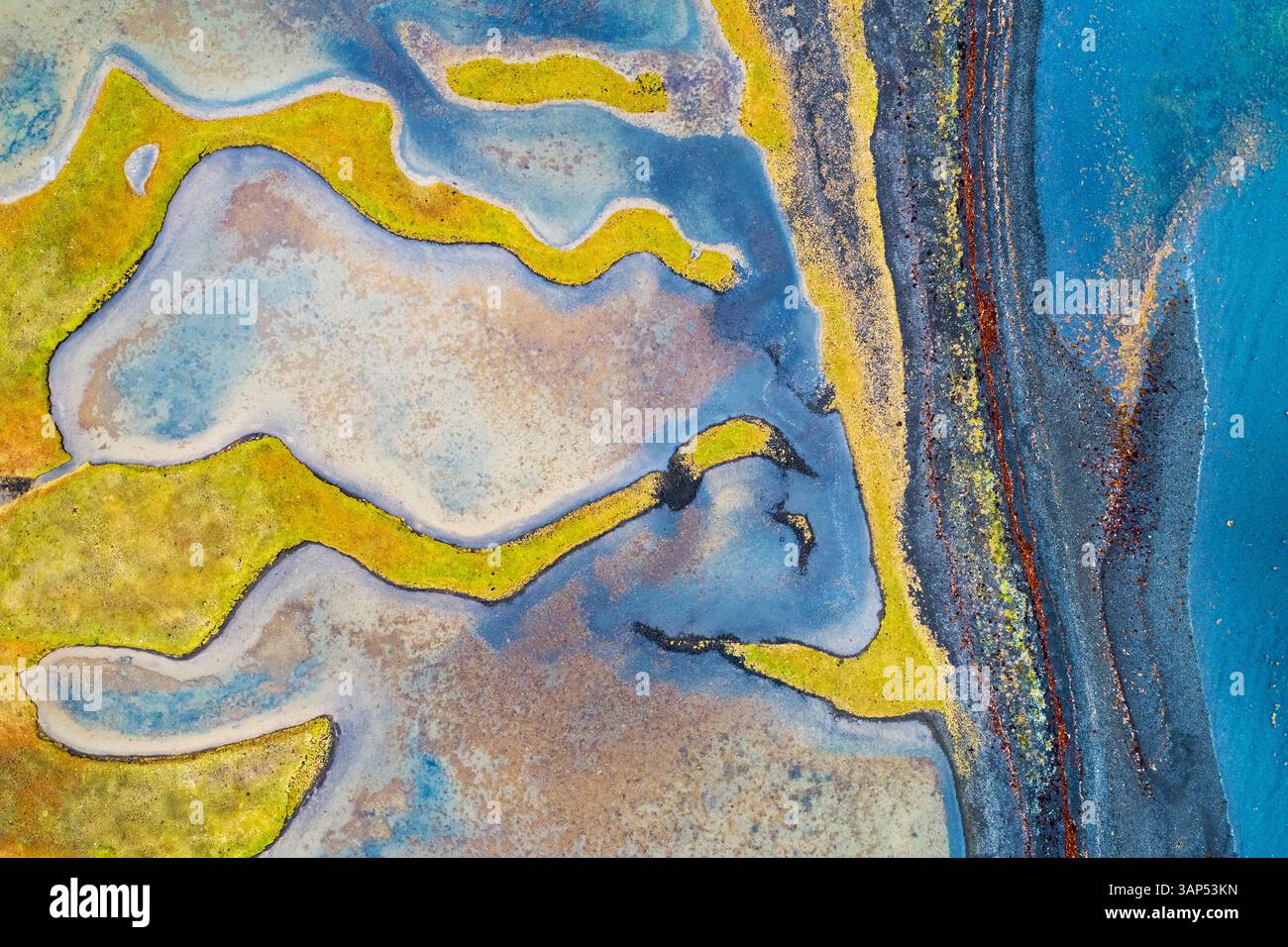 Abstract aerial view of small strips of grassland just behind a black ...
