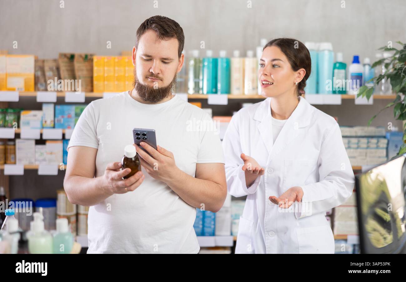 Man buyer scans syrup qr code with woman pharmacist Stock Photo - Alamy