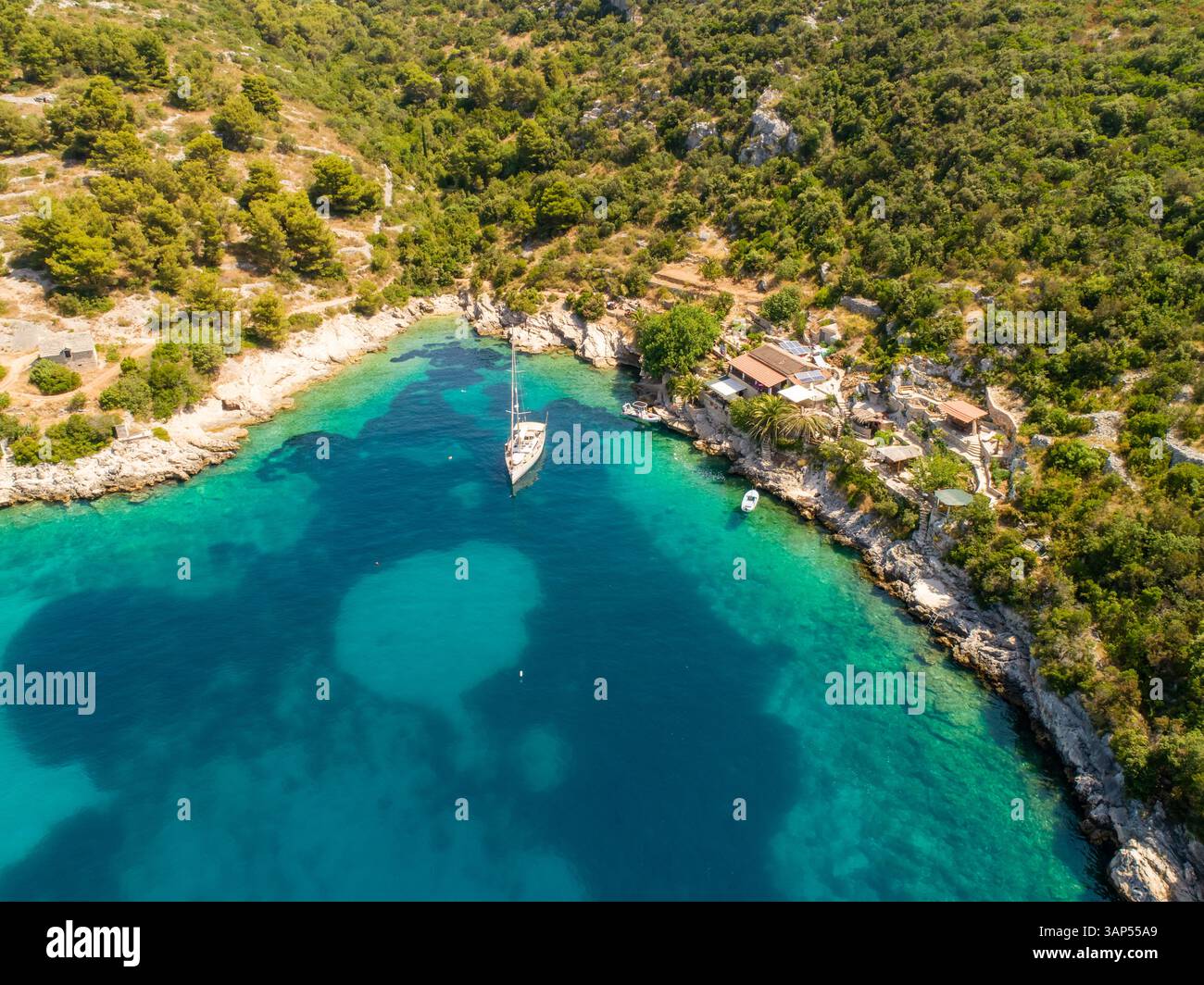 Aerial view of single sail boat anchored in hidden Tatinja bay, Solta ...